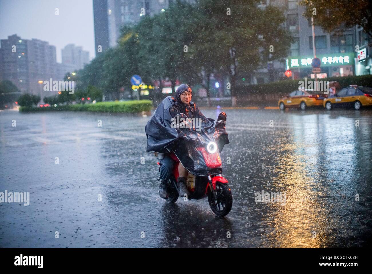 Motor, pedestrians and vehicles trek in the downpour, which might be ...