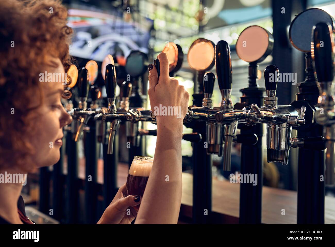 Female barkeeper tapping beer in a pub Stock Photo - Alamy