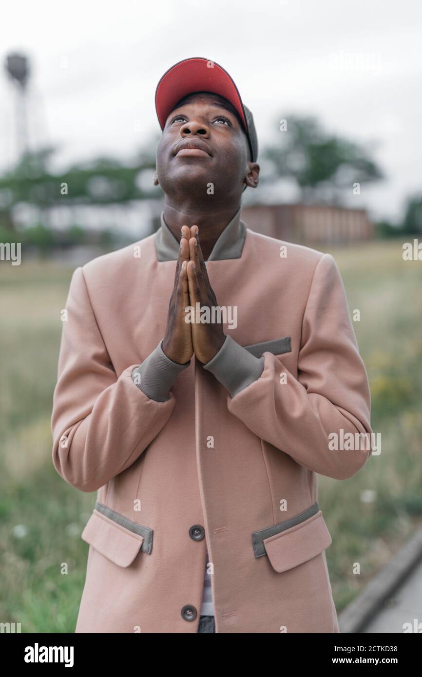 Young man praying with religious faith while standing outdoors Stock ...