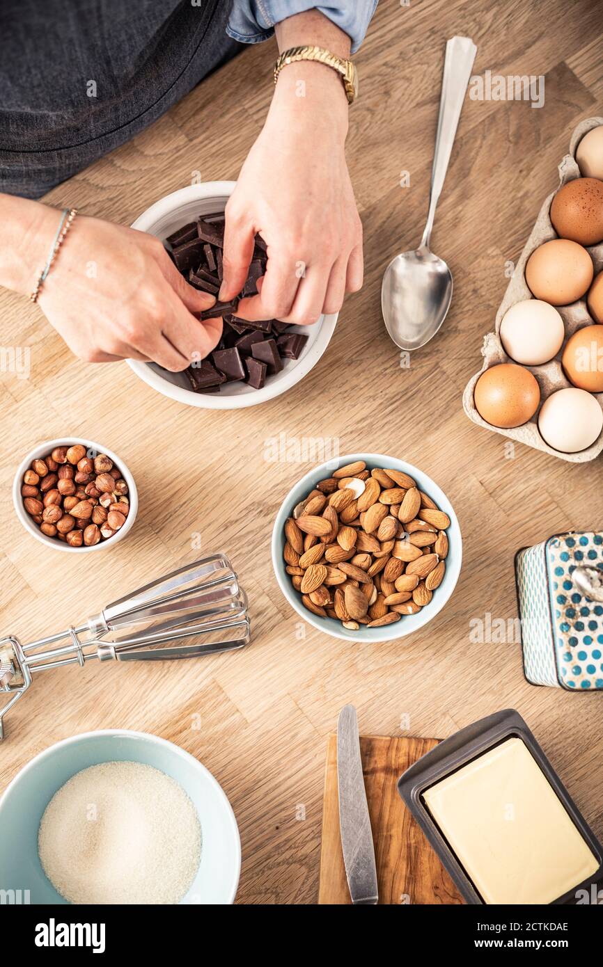 Woman hand making piece of chocolate while standing at kitchen island ...