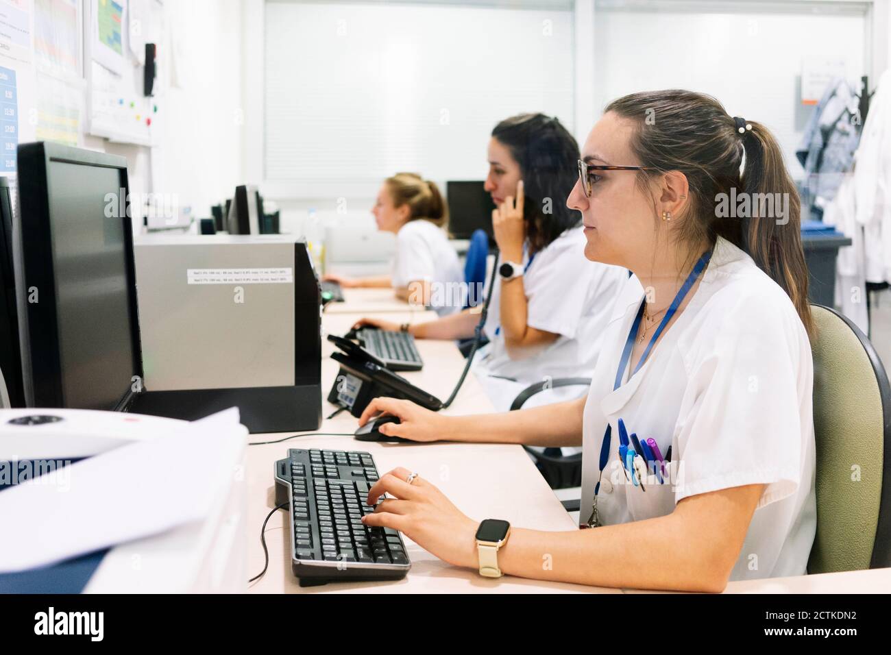 Female coworkers using computers on desk in pharmacy at hospital Stock ...