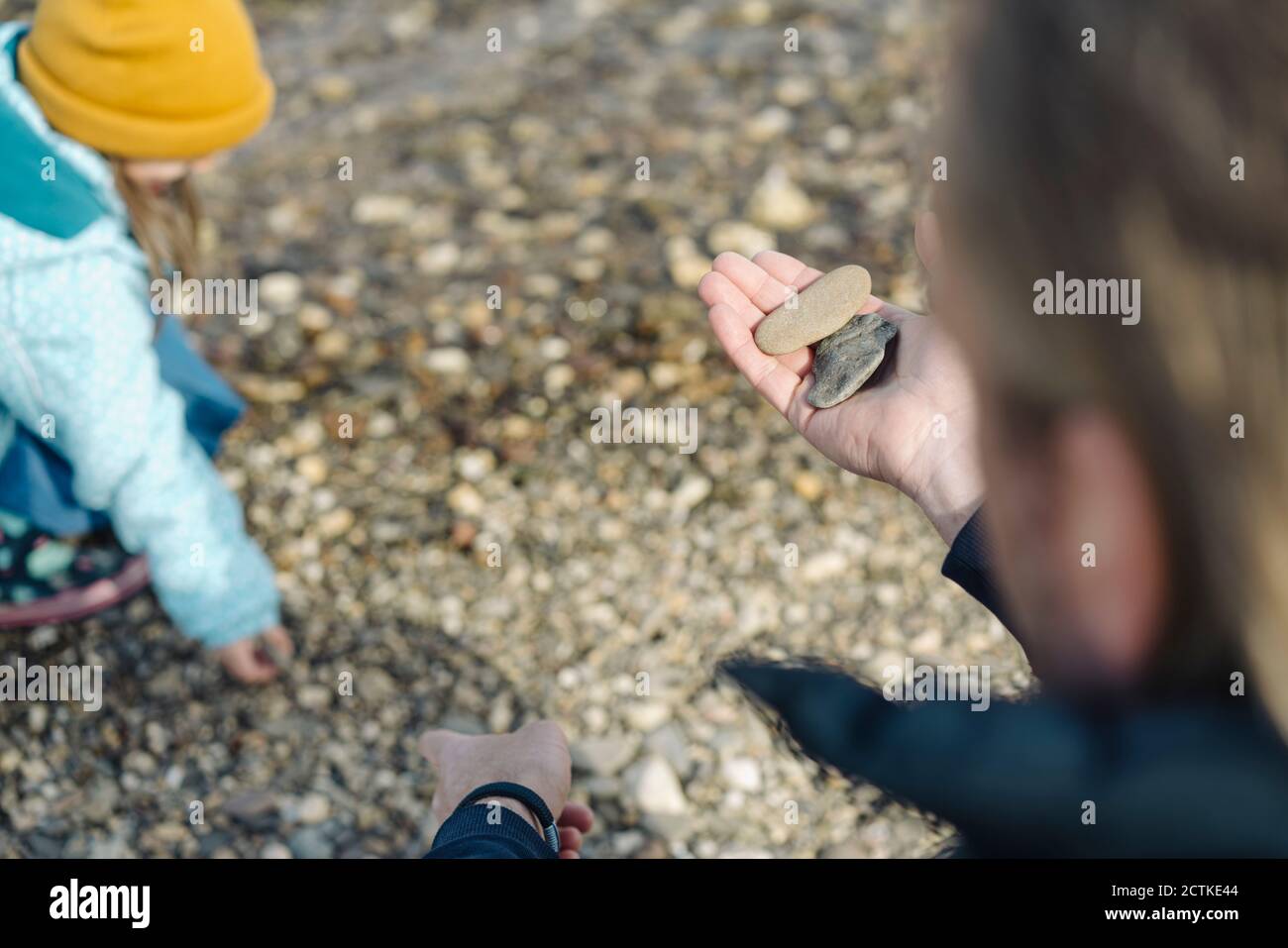 Father and daughter collecting pebbles near river bank Stock Photo - Alamy