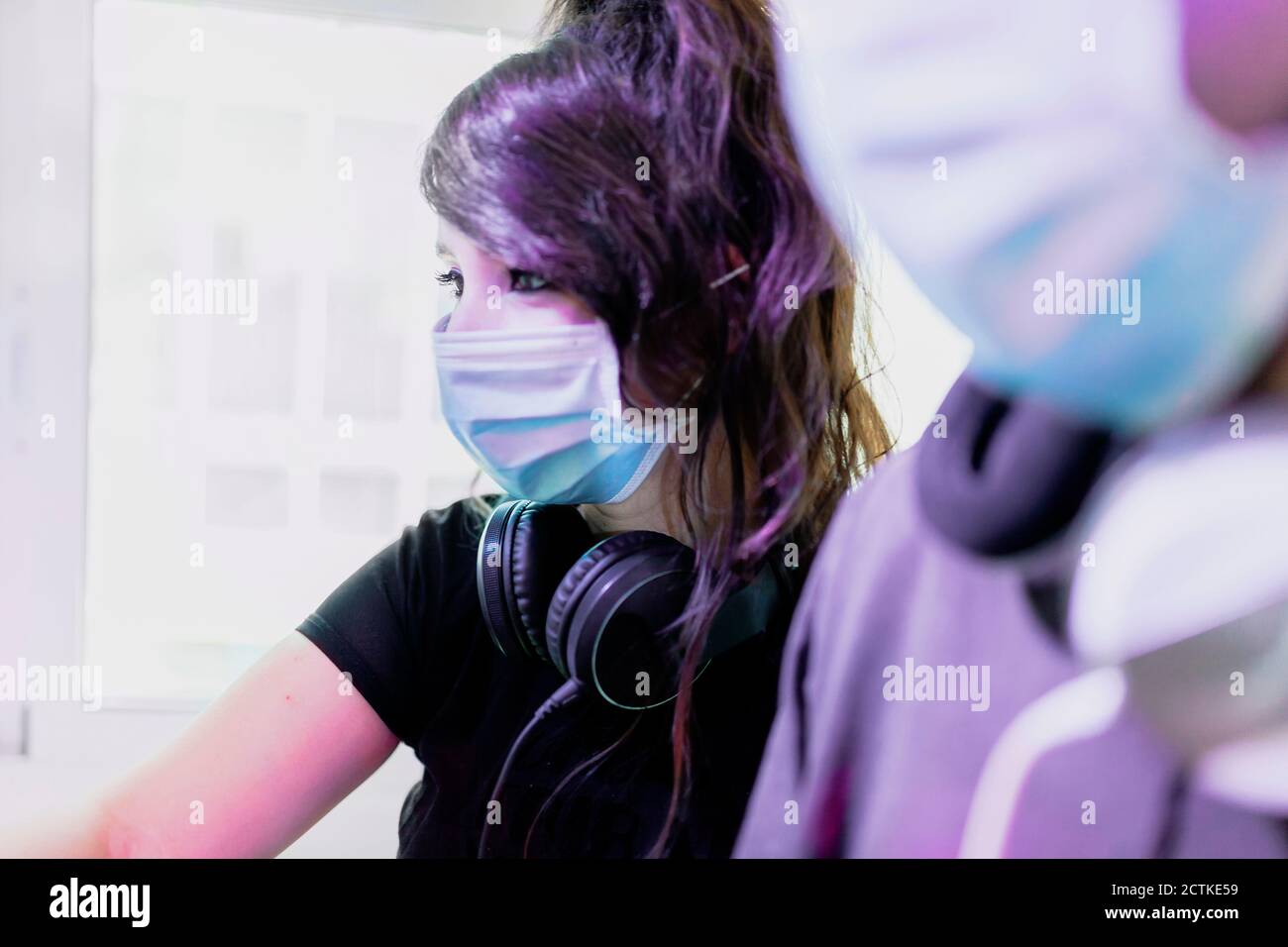 Female musician wearing face mask by boyfriend at recording studio ...