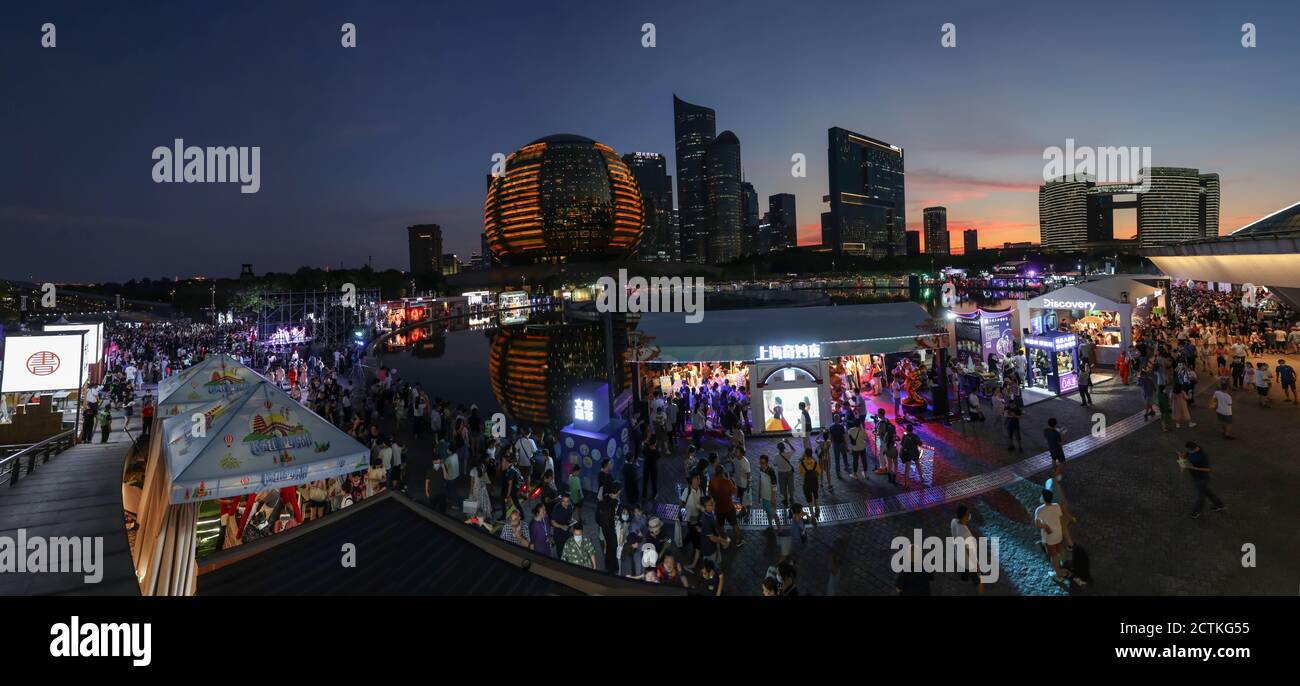 People walk around and shop at the "2020 Amazing Night in Hangzhou", a ...