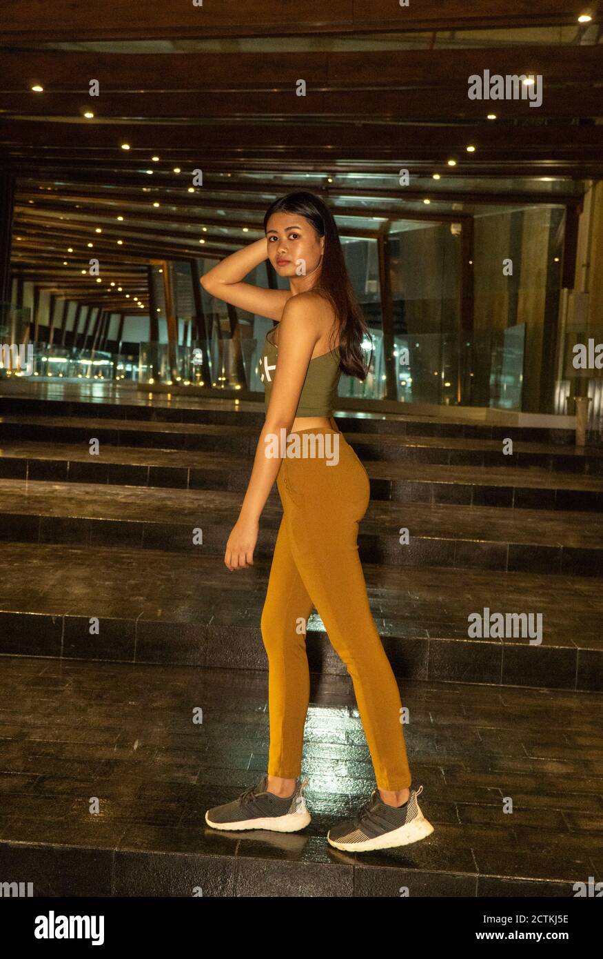 Teenage girl night posing for camera in dark lite walkway Stock Photo ...