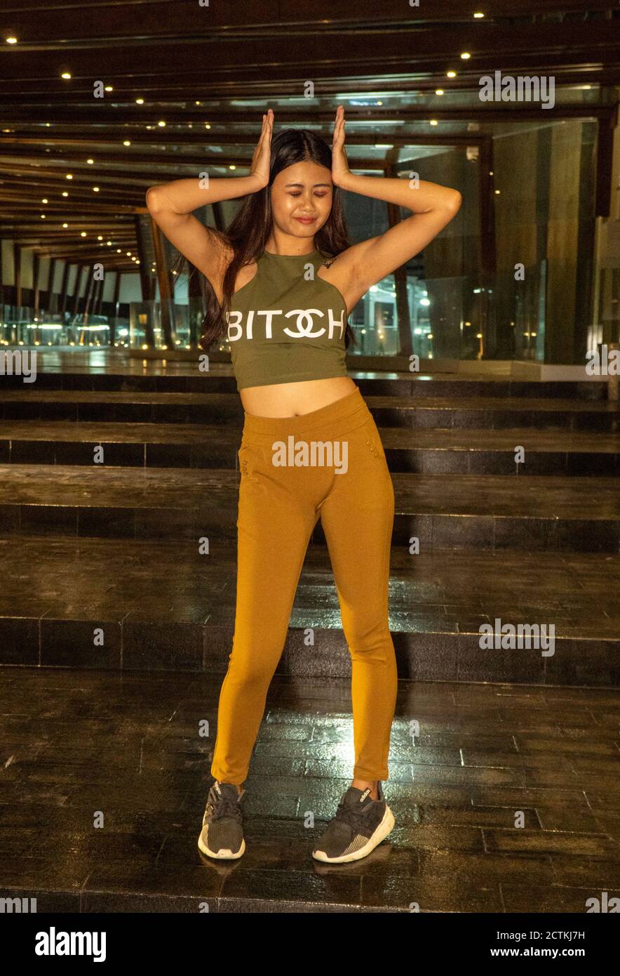 Teenage girl night posing for camera in dark lite walkway Stock Photo ...