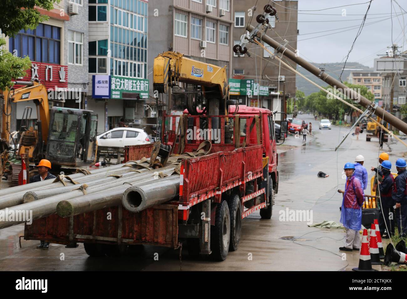 Staff from local electricity company are busy at repairing utility ...