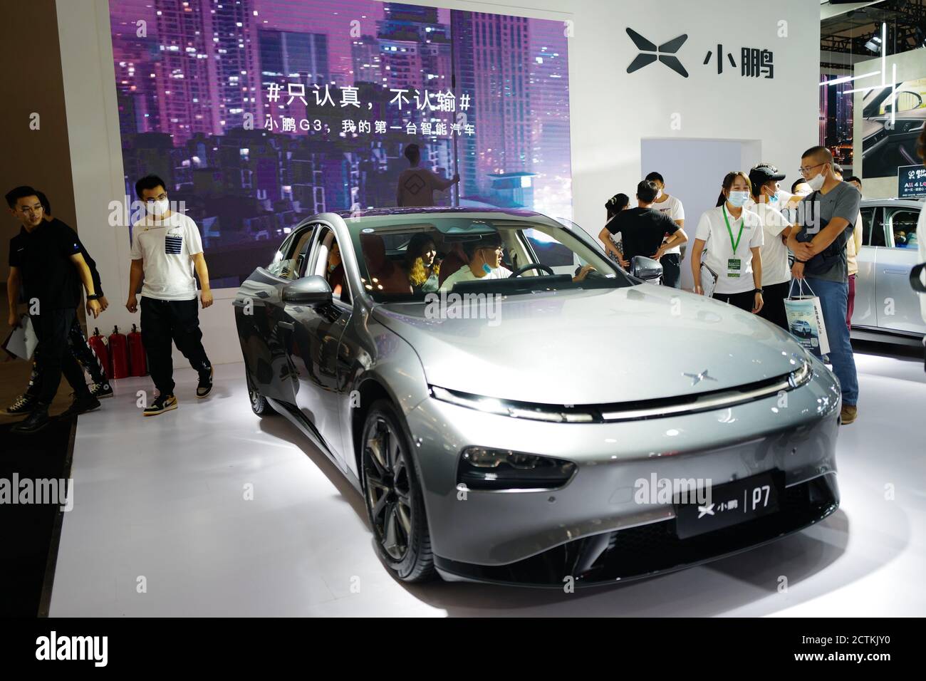 Visitors flock to the booth of XPeng, also known as Xiaopeng Motors, a ...