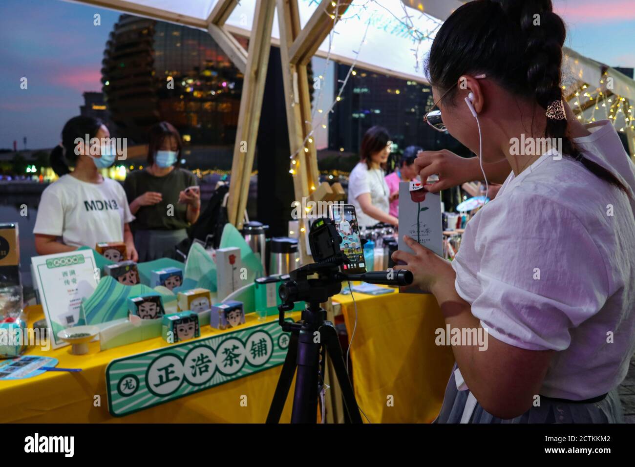 People walk around and shop at the "2020 Amazing Night in Hangzhou", a ...