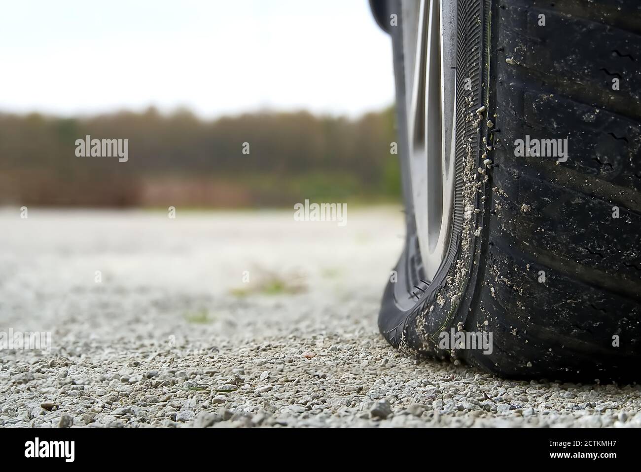 Close-up of Flat rear tire on car. The right rear broken weel. Damaged ...