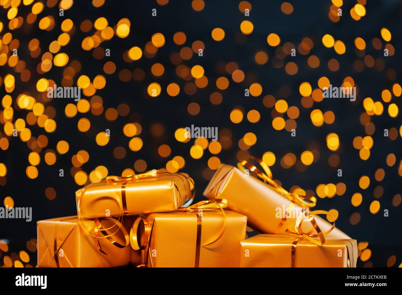Wrapped Christmas gifts on golden lights bokeh background Stock Photo ...