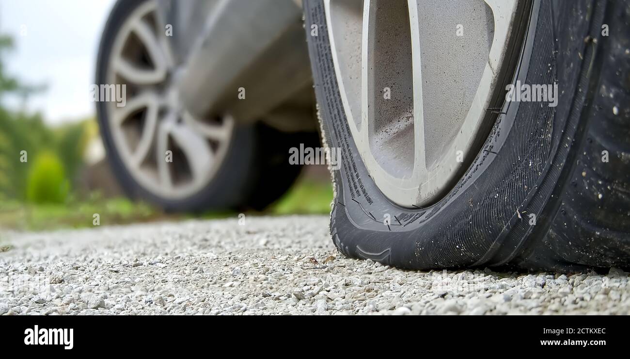Close-up of Flat rear tire on car. The right rear broken weel. Damaged ...