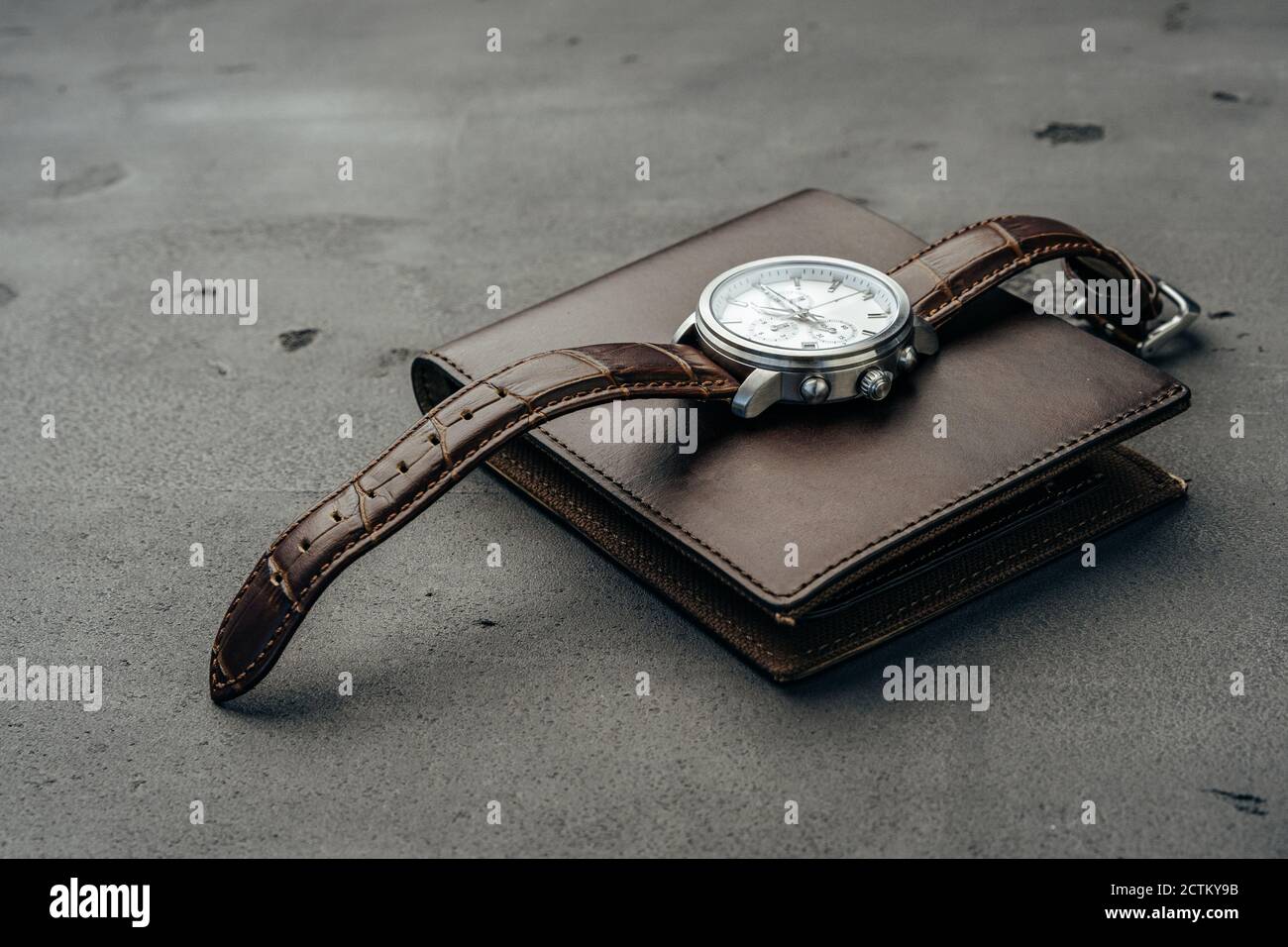 Male watch and leather wallet on dark grey surface Stock Photo - Alamy