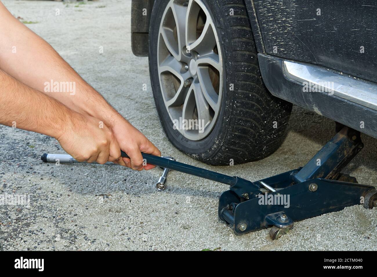 Man changing wheel. tire changer changing flat car tire. Help on road ...