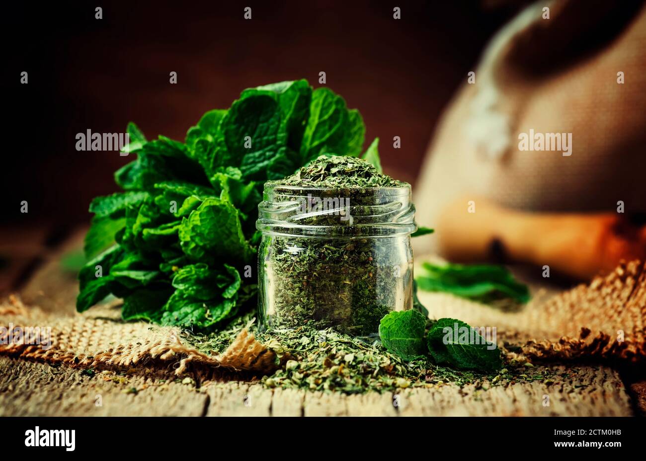 Dried peppermint in a glass jar and a bunch of fresh mint, vintage wood ...