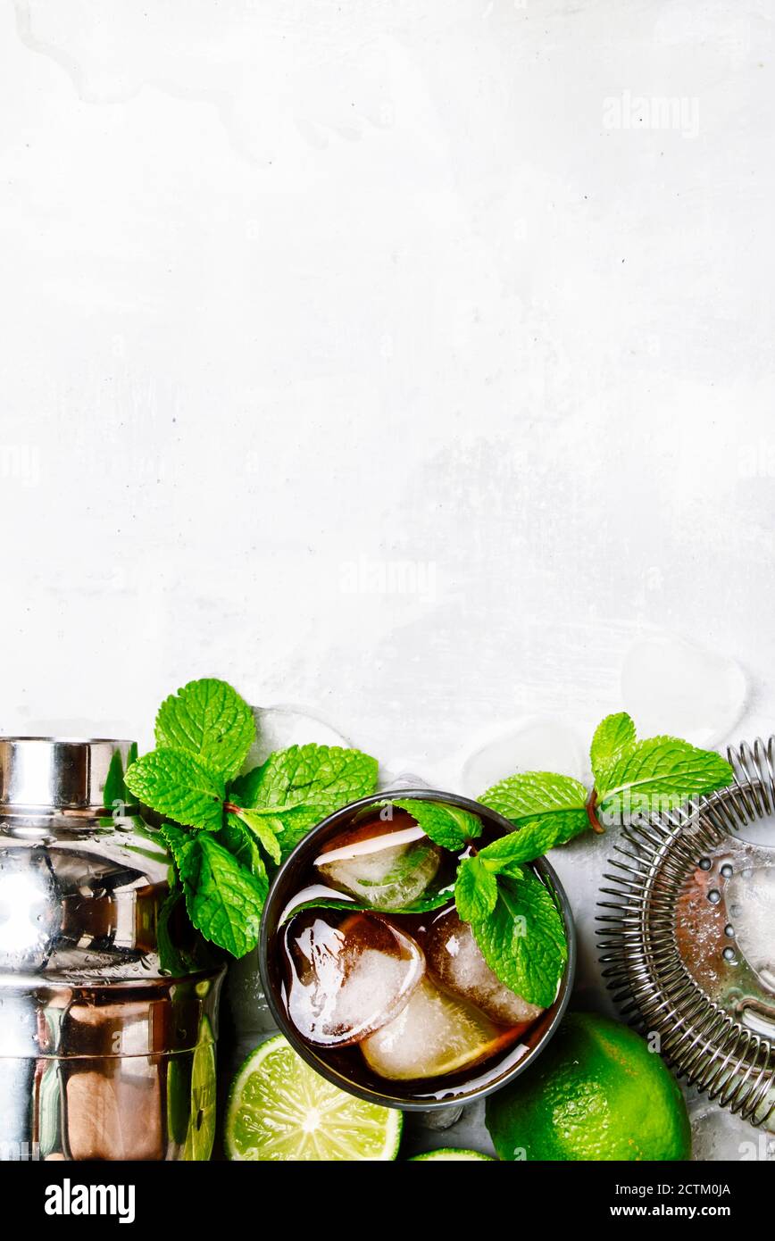 Alcoholic cocktail with rum, cola, ice and mint, bar tools, drink ...