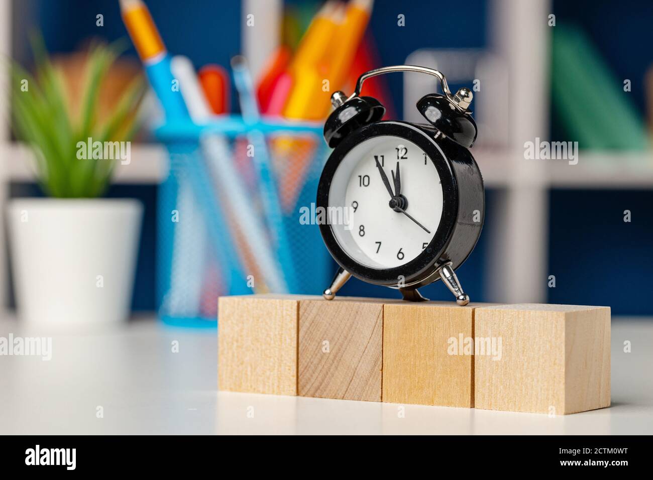 Four wooden cubes with copy space and alarm clock Stock Photo - Alamy