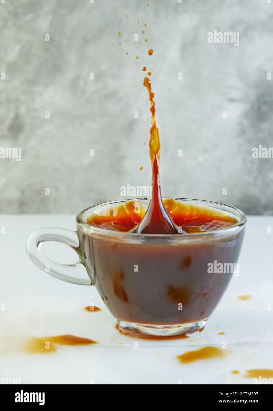 Splash of coffee in a cup with a drink on a gray-white background Stock ...