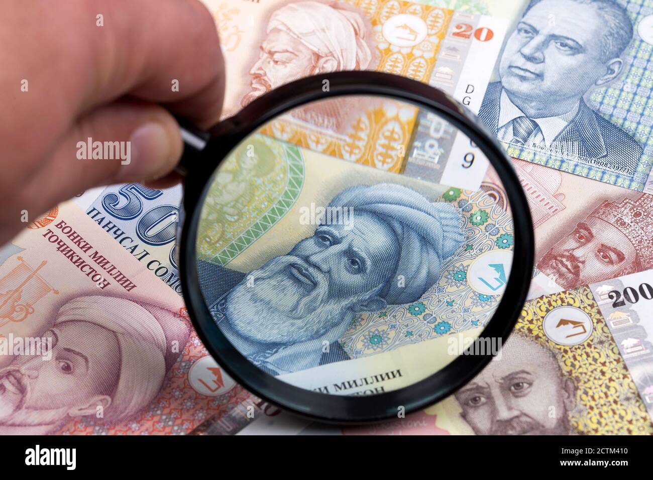 Tajikistani somoni in a magnifying glass a business background Stock ...