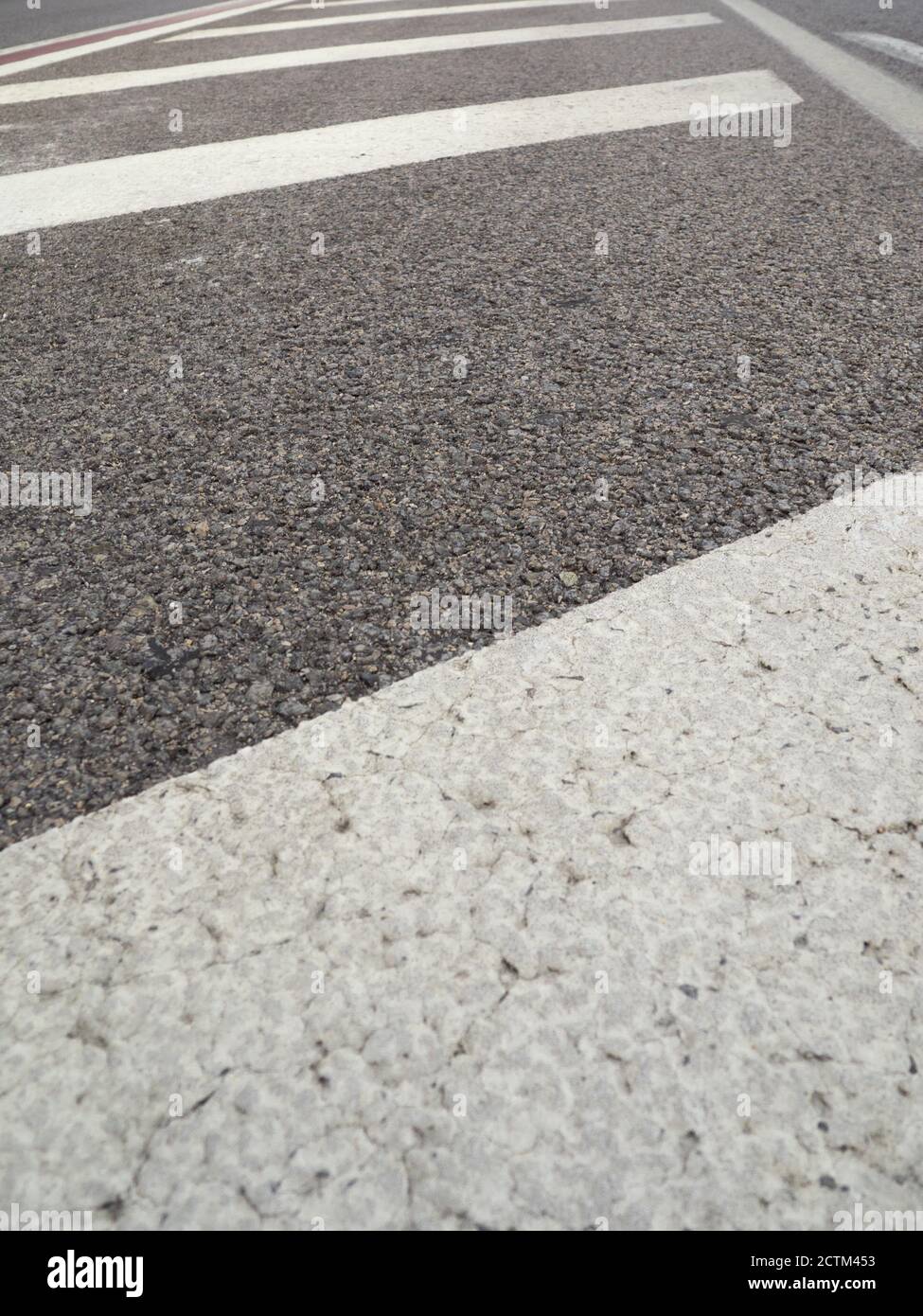 Closeup shot of a tar or asphalt pavement texture with white lines ...