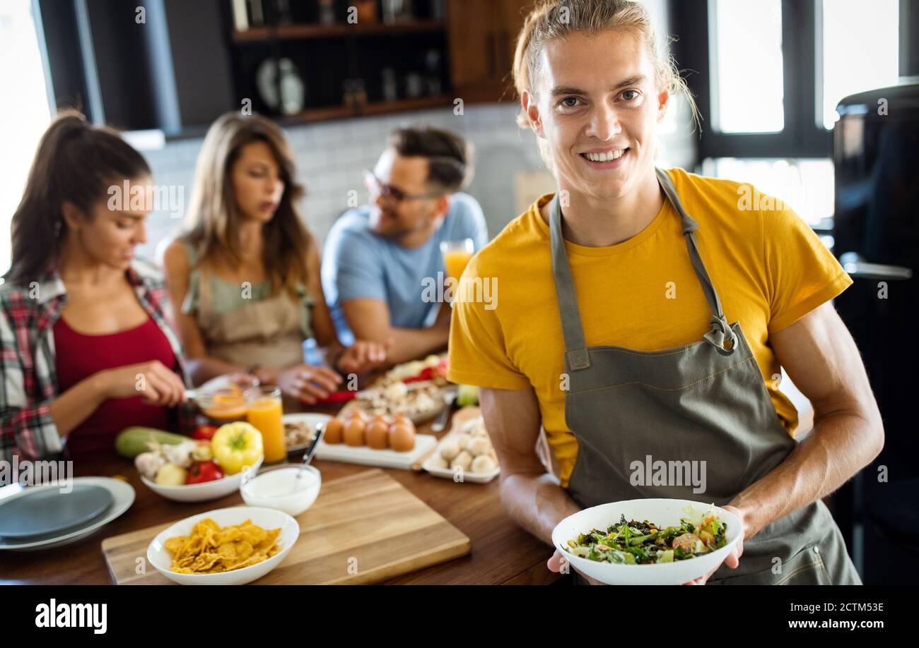 Beautiful happy people, friends is smiling while cooking together in ...