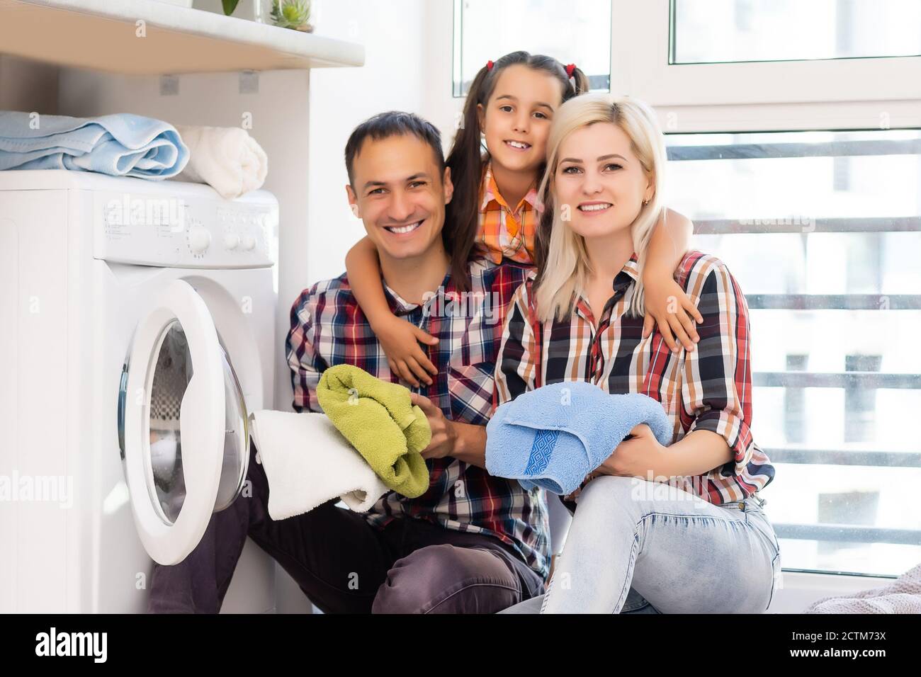 Happy family is doing the laundry Stock Photo - Alamy