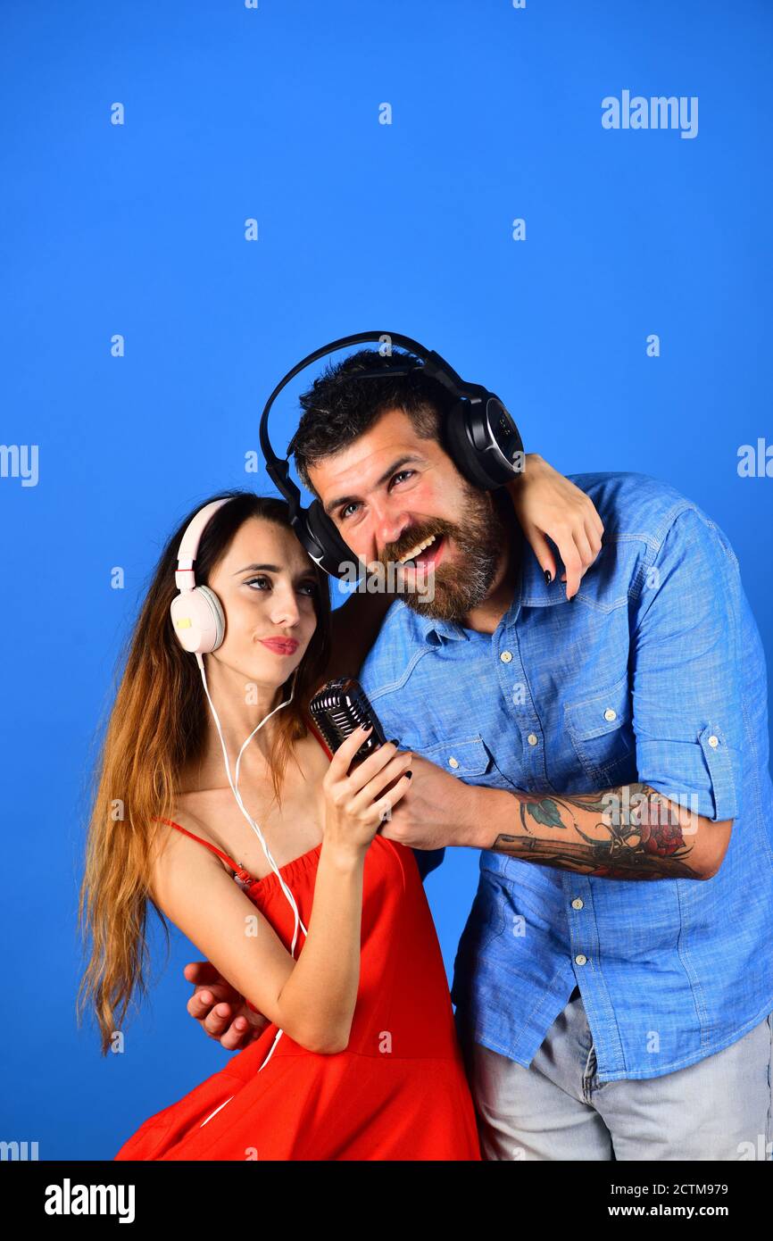 Party and music concept. Couple in love wears headphones and holds ...