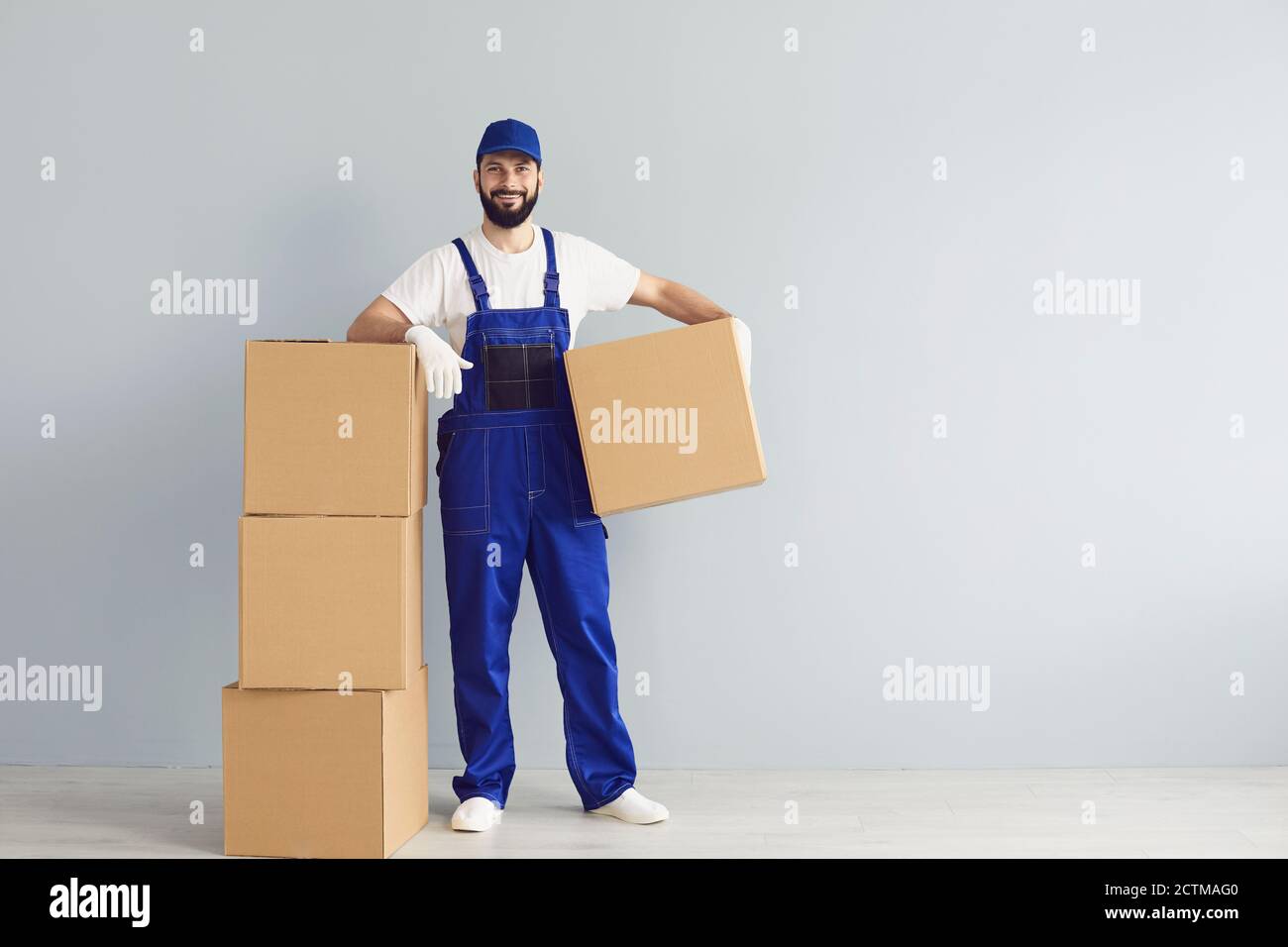 Happy delivery man with boxes Stock Photo - Alamy