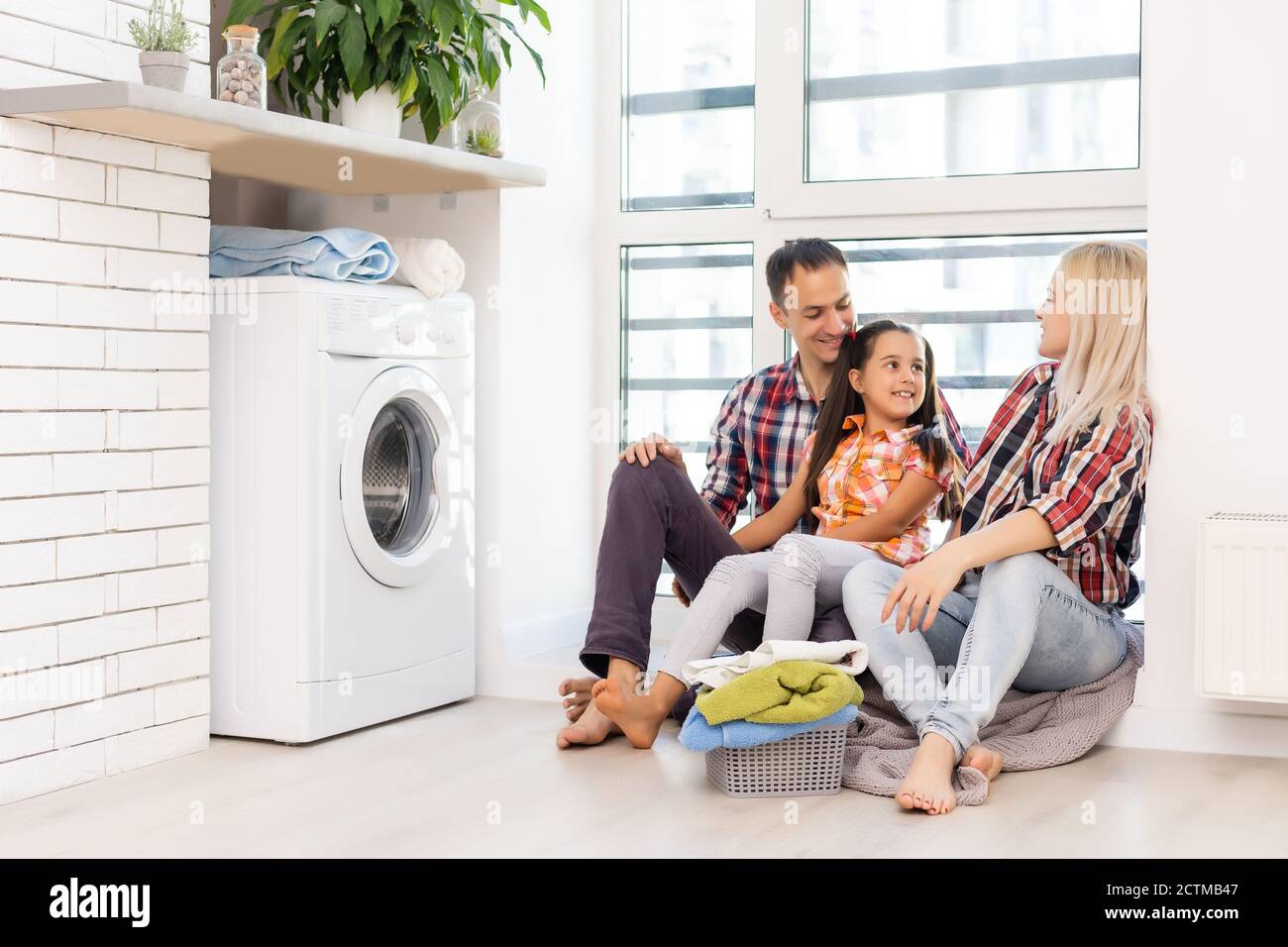 the image of a happy family doing laundry Stock Photo - Alamy