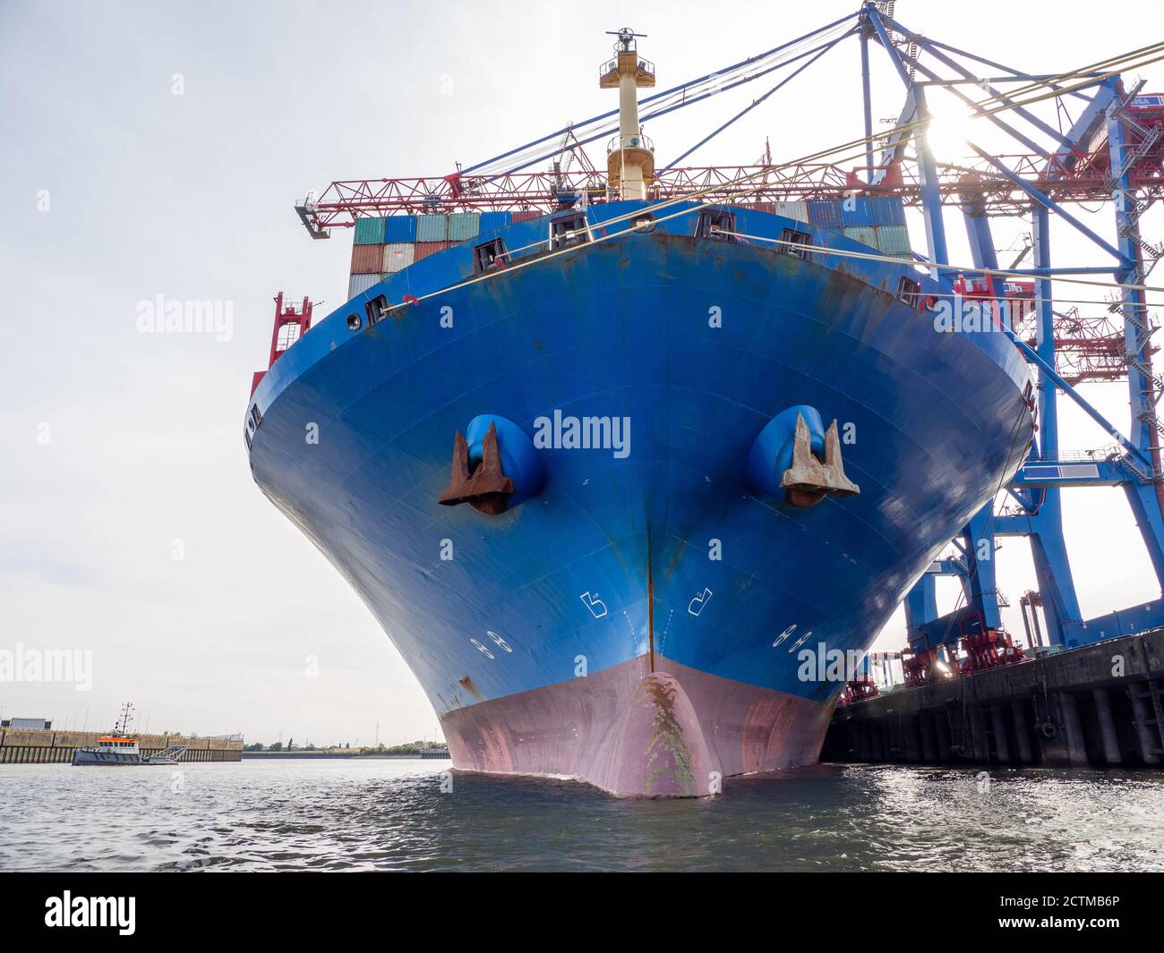 in a port there is a huge blue container ship Stock Photo - Alamy