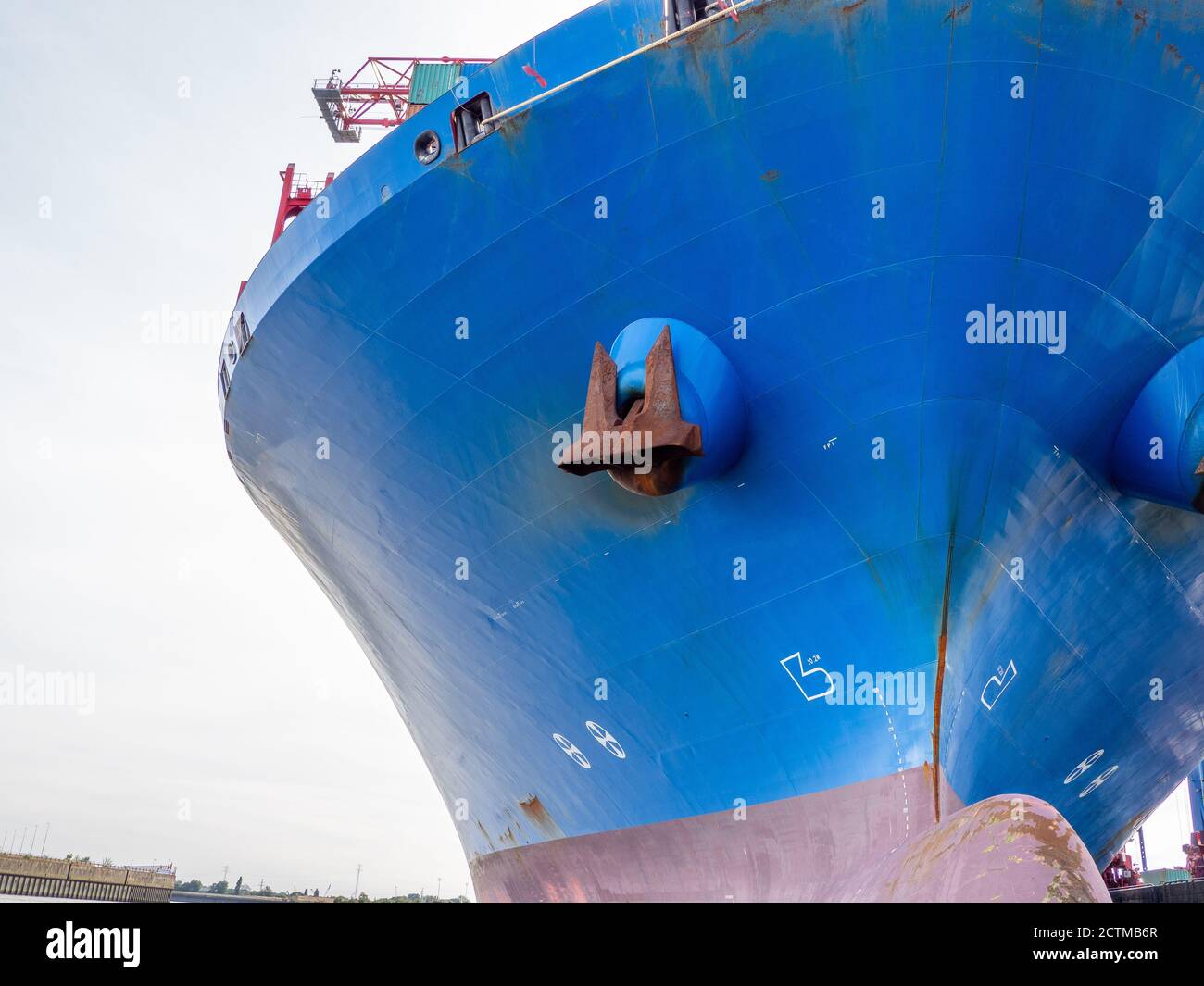in a port there is a huge blue container ship Stock Photo - Alamy