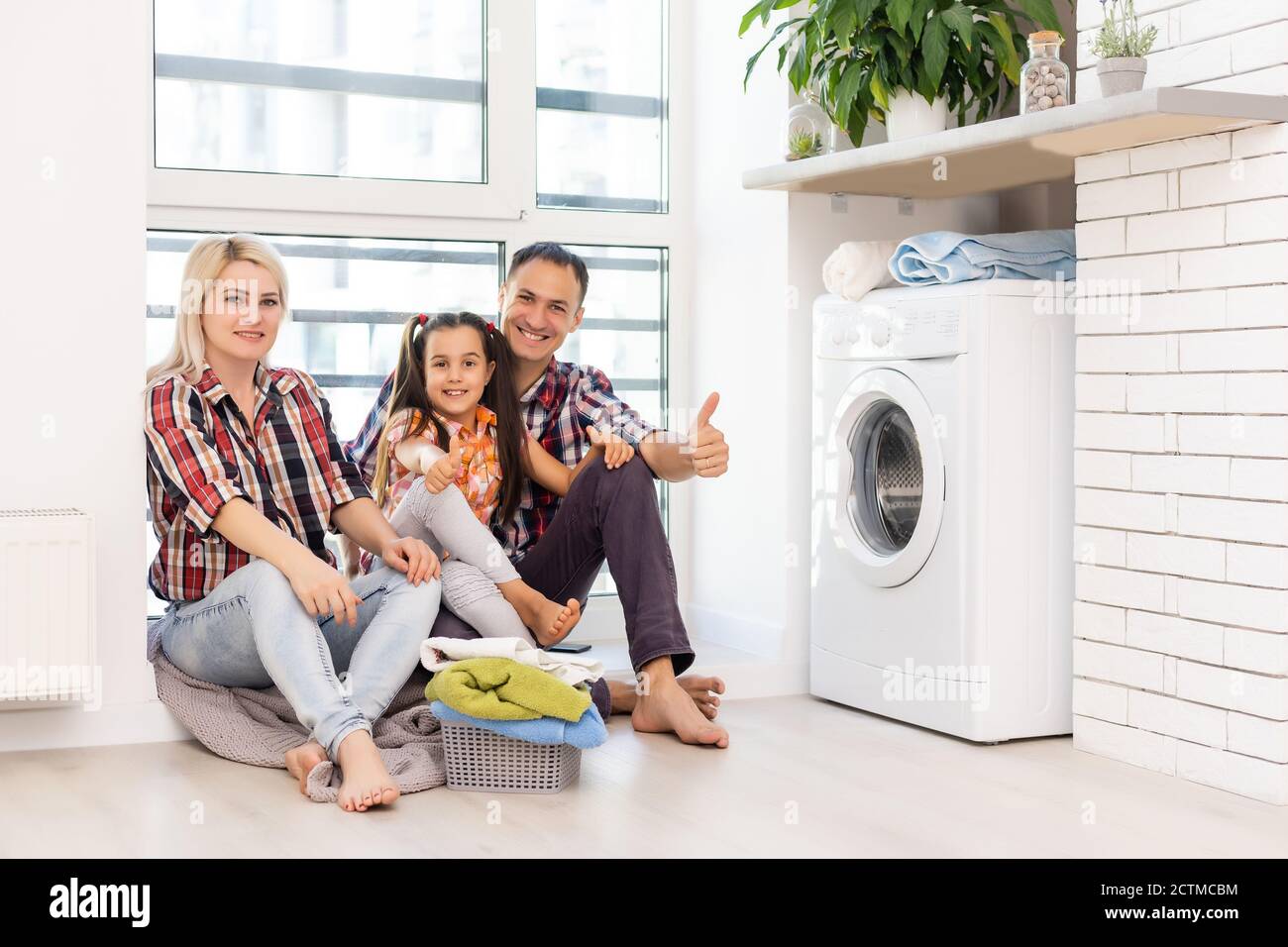 the image of a happy family doing laundry Stock Photo - Alamy