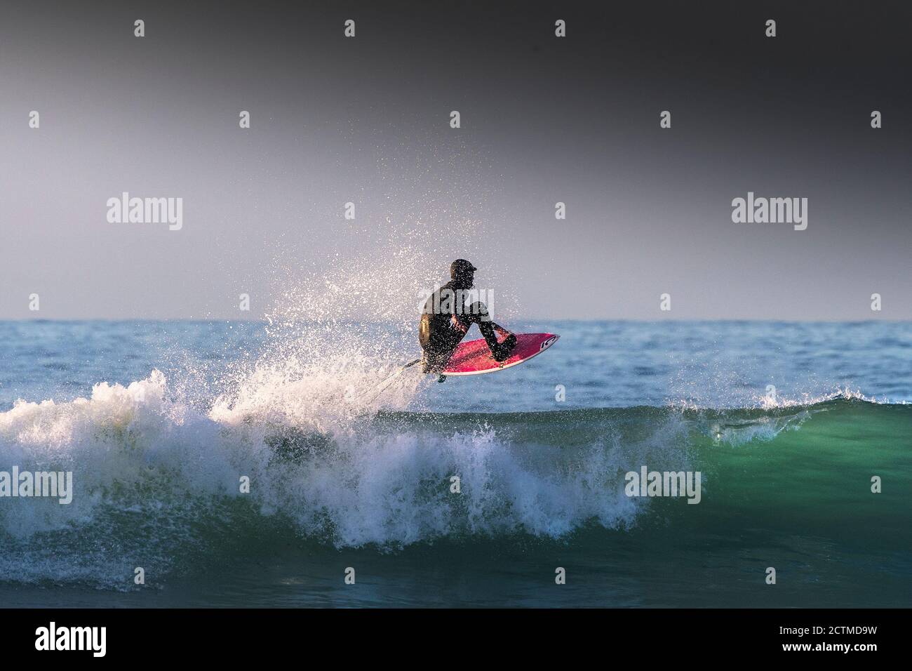 Spectacular surfing action as a surfer performs an aerial trick off the ...
