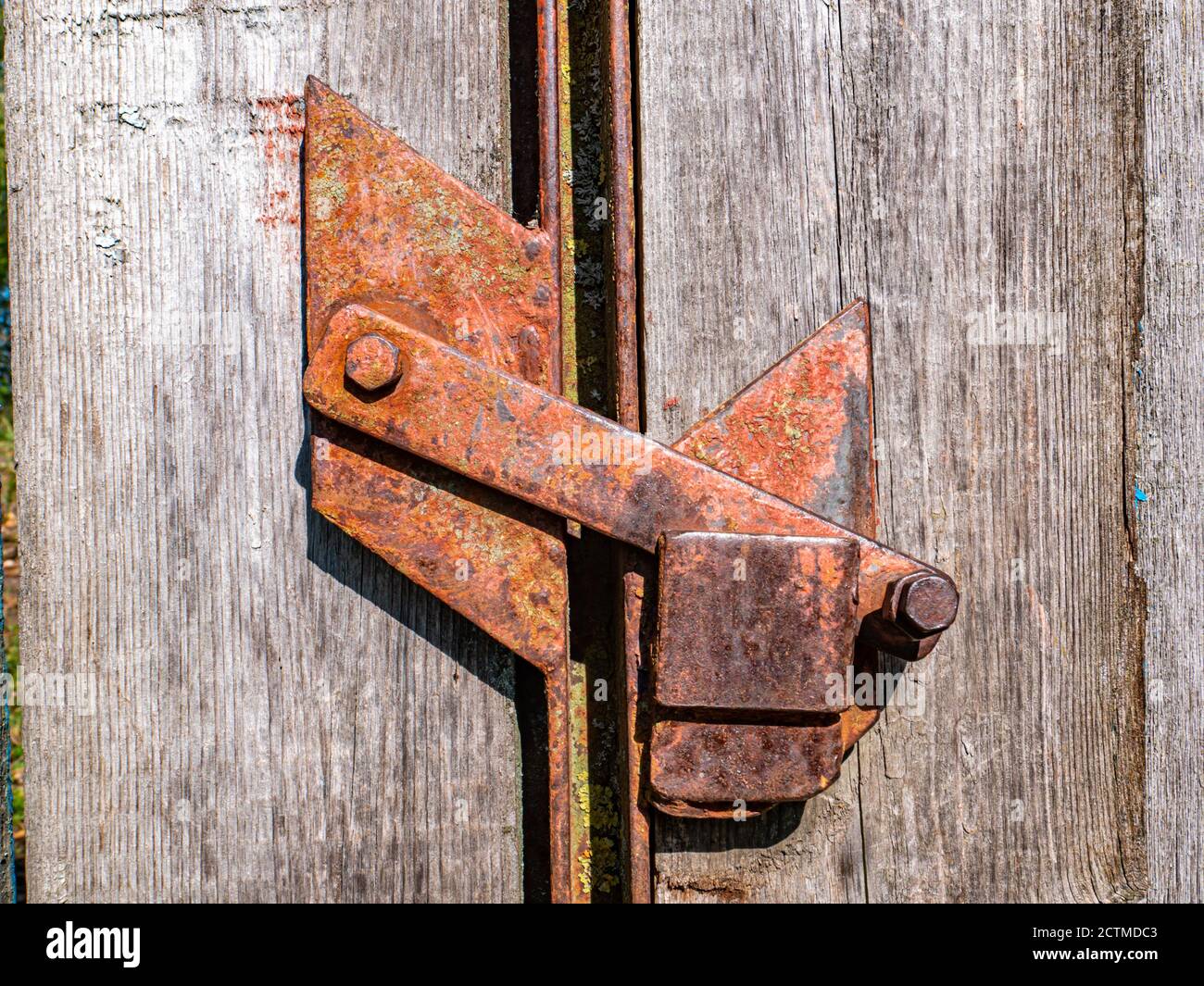Old rusty iron bolt of a wooden gate lock Stock Photo - Alamy