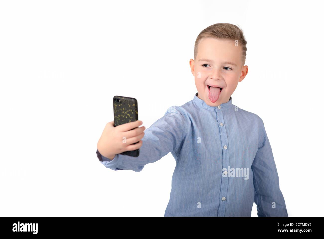 European Boy in blue shirt makes selfie on phone isolated on white ...