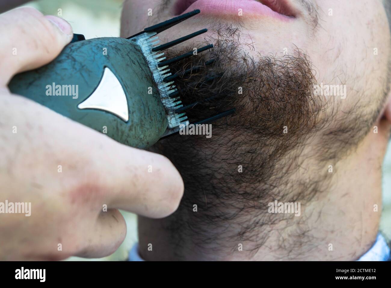 the barber cuts his beard to the guy with a shearing machine Stock ...