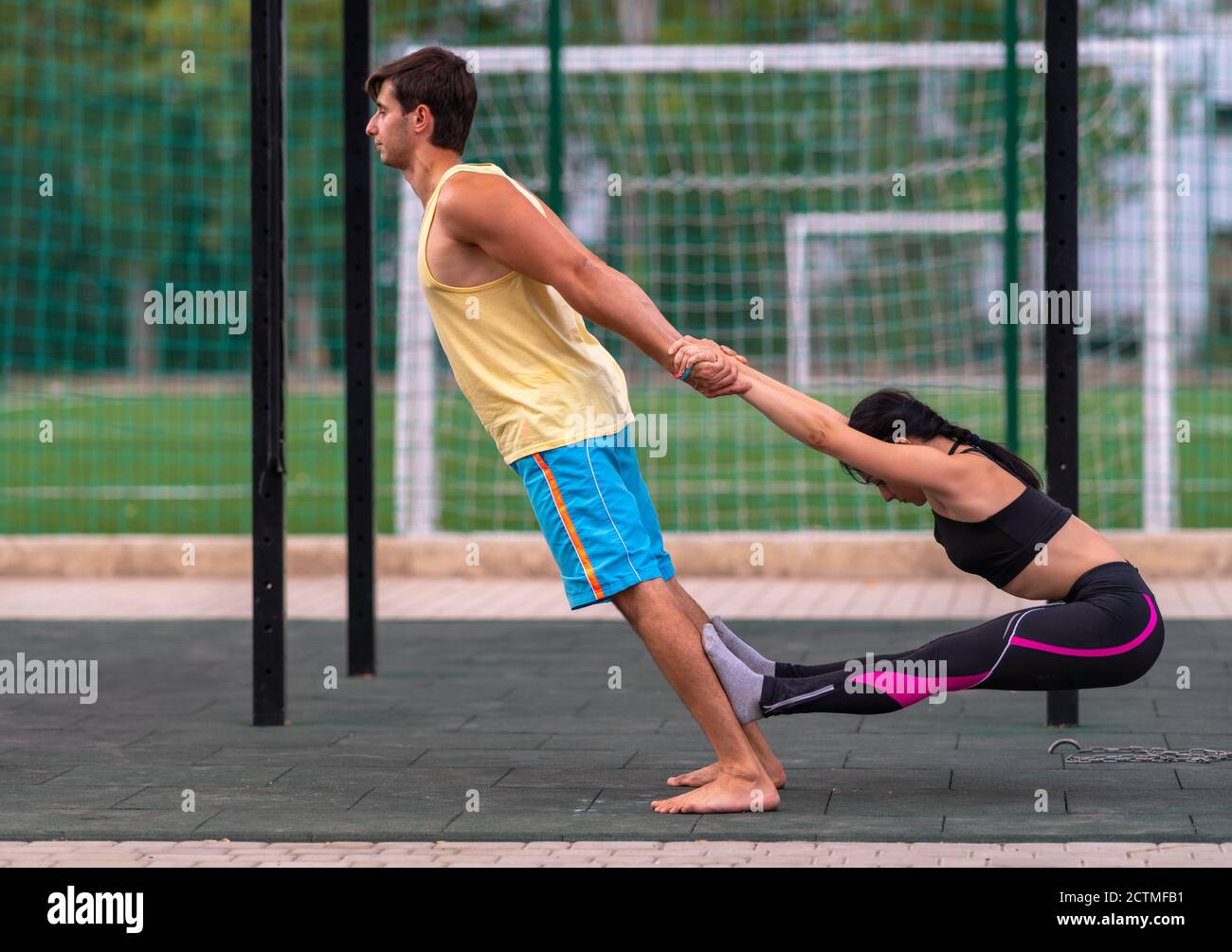Side view of a young couple working out as a team striking a joint ...