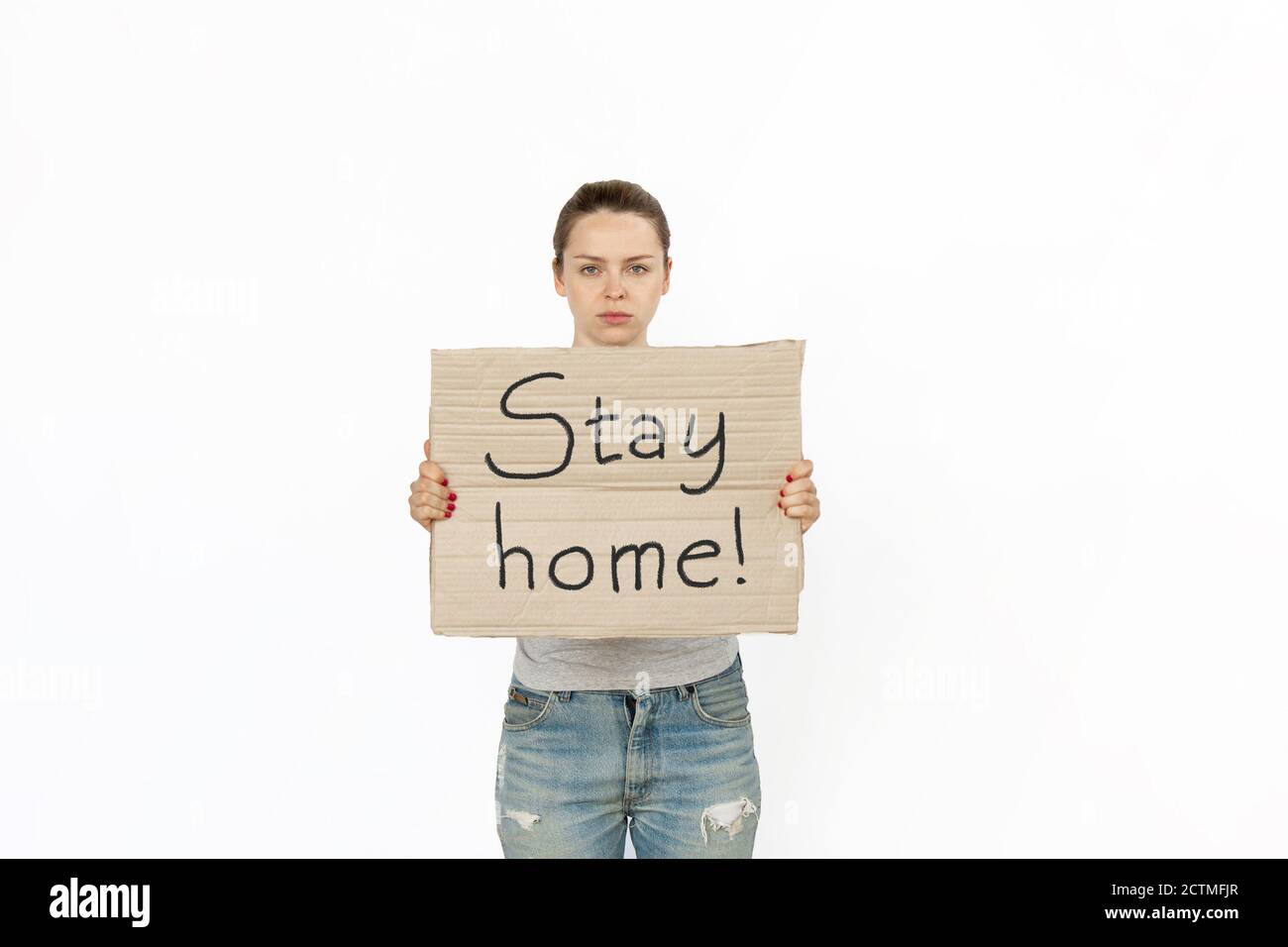 Stay home. Young woman protesting with sign isolated on white studio ...