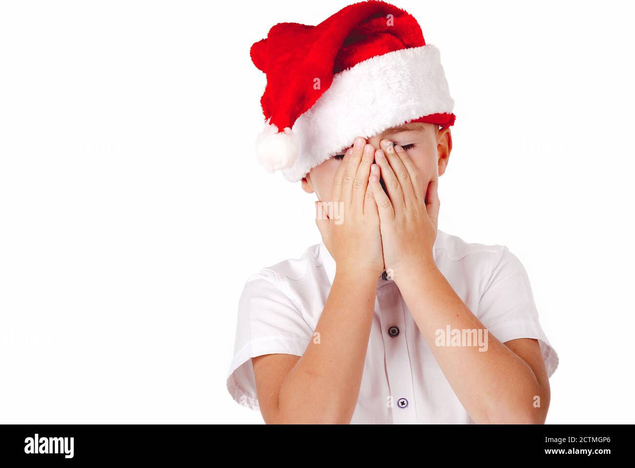 Schoolboy with red hat of Christmas on a over white background Stock ...