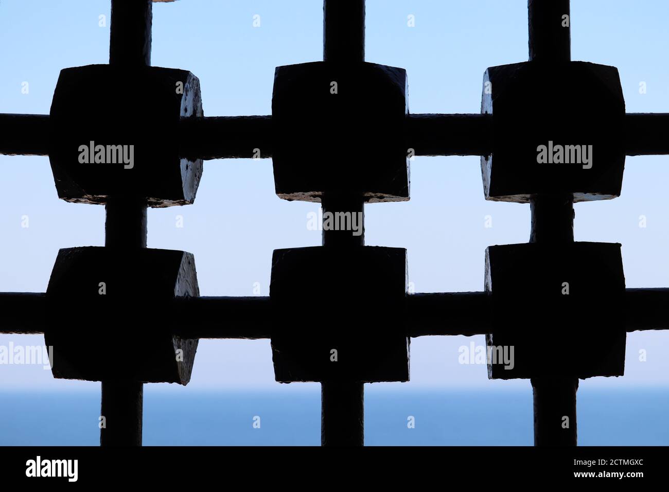 View through ancient metal lattice to sea and sky. Latticed window of ...