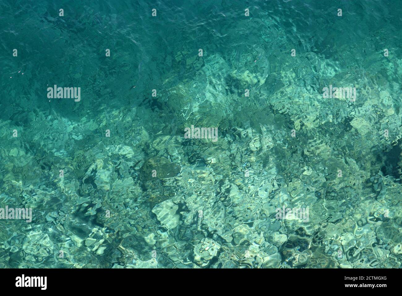Azure water texture, transparent sea surface with a rocky bottom ...