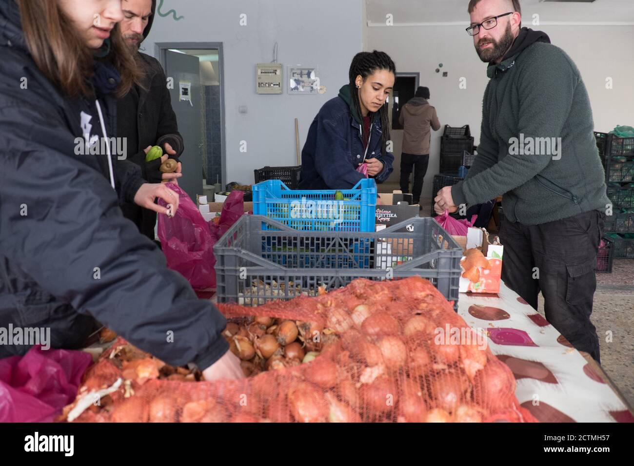 Volunteers organise food distribution in a charity warehouse in ...