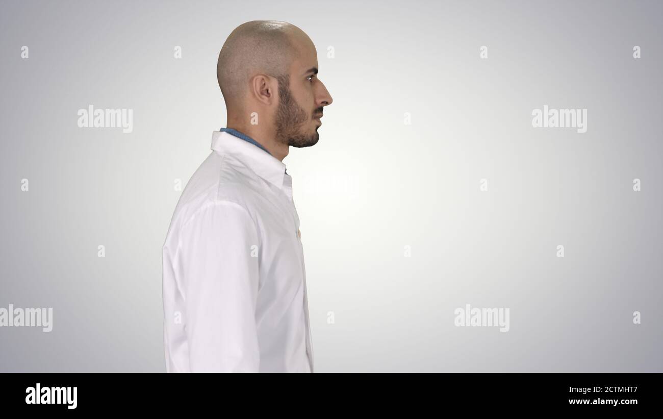 Arabian doctor in white robe walking on gradient background Stock Photo ...