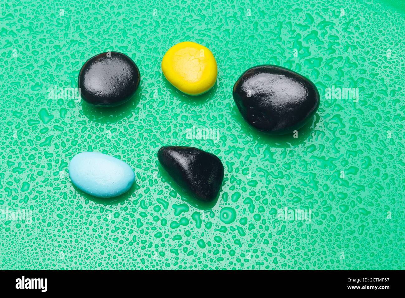 Color stones on a green background; various colors, yellow, black ...