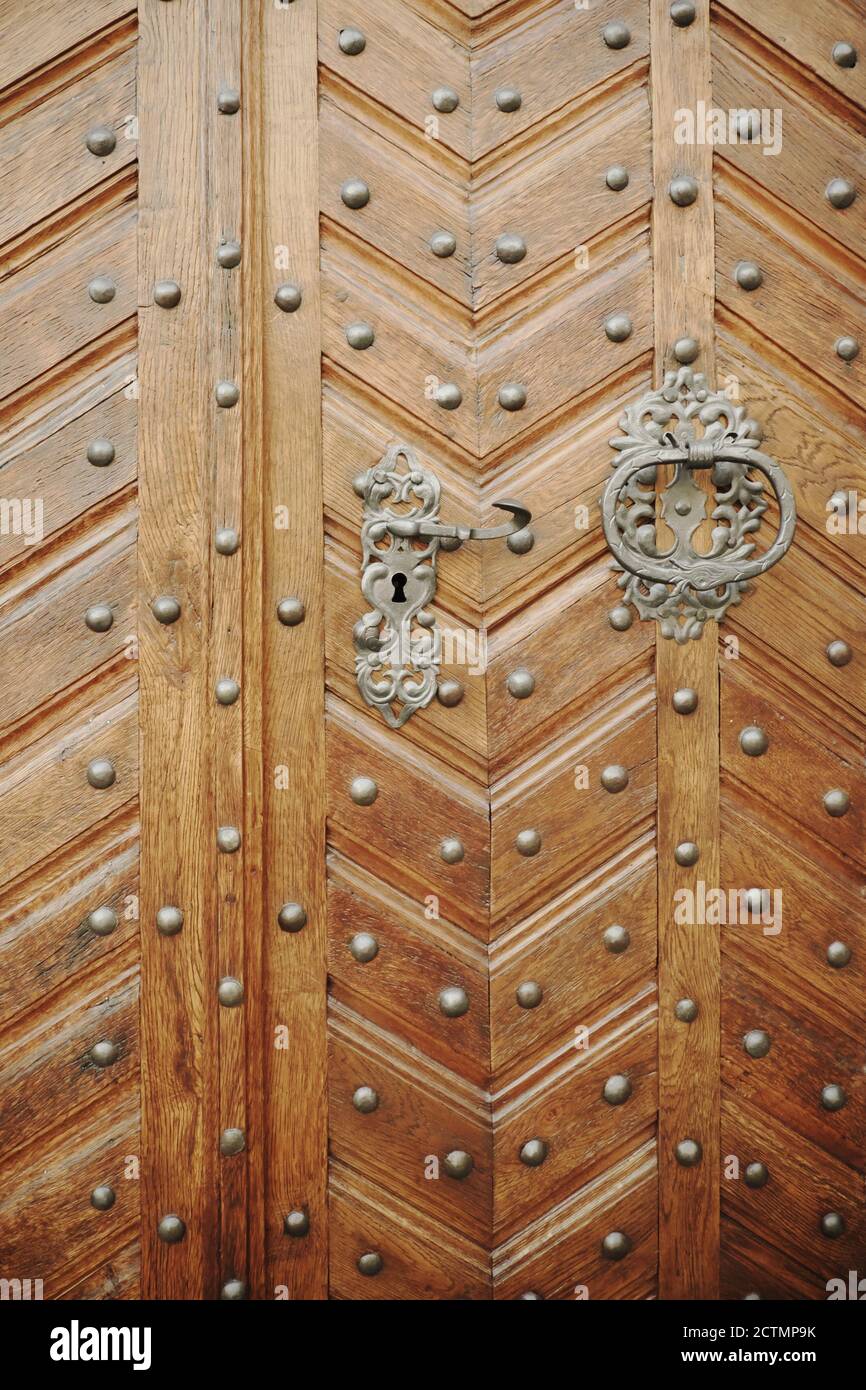 Old wooden door with rivets. Metal handle and door lock Stock Photo - Alamy