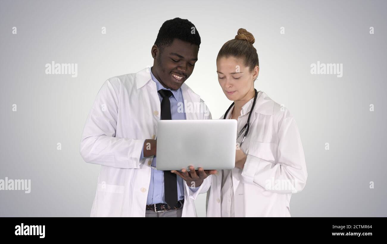 Medical staff working in front of a grey laptop while standing o Stock ...