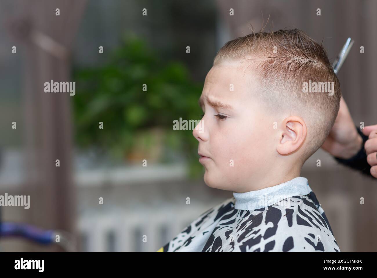 Hairdresser makes a stylish hairstyle. The woman is standing and making ...