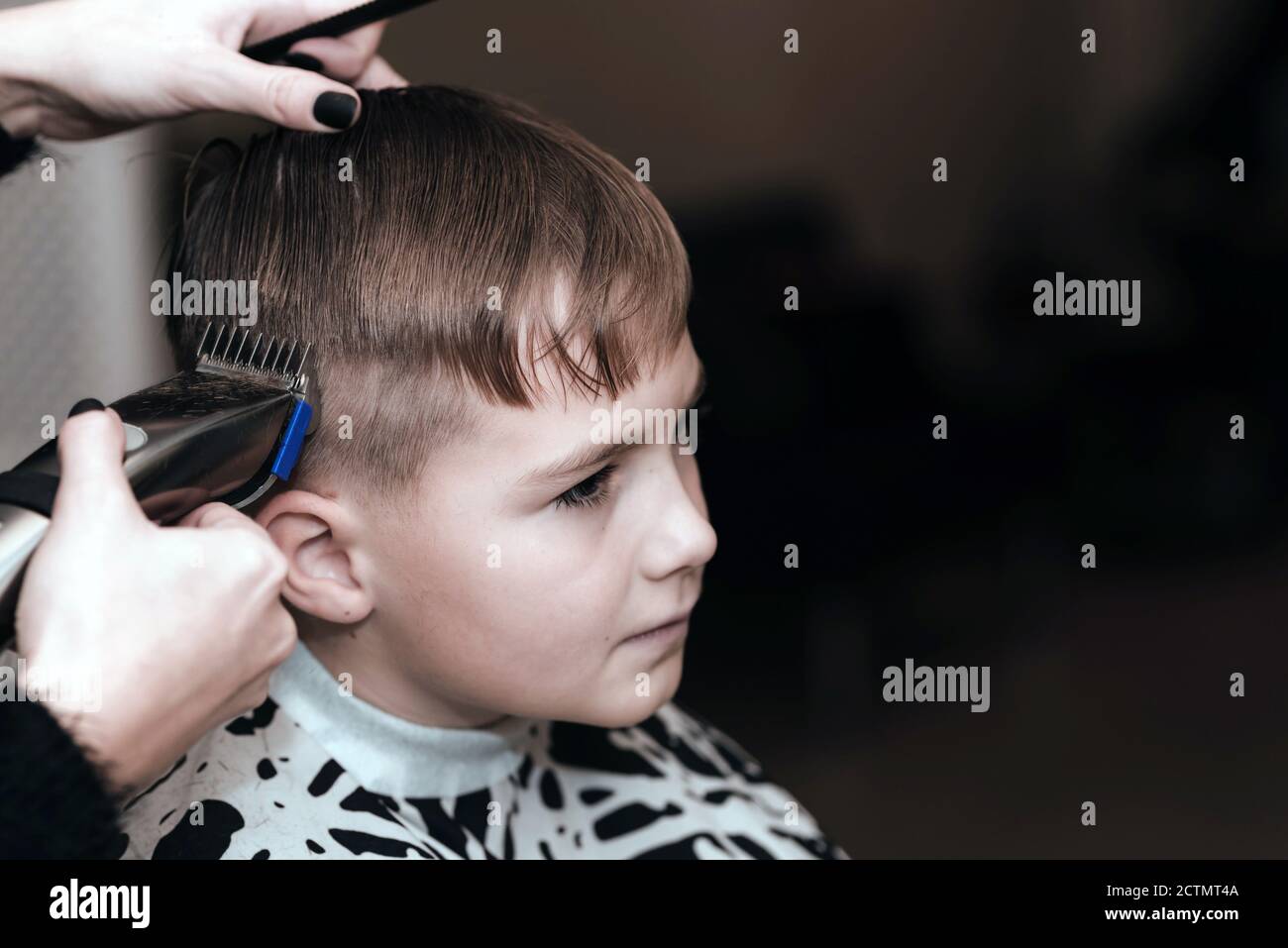 Hairdresser makes a stylish hairstyle. The woman is standing and making ...