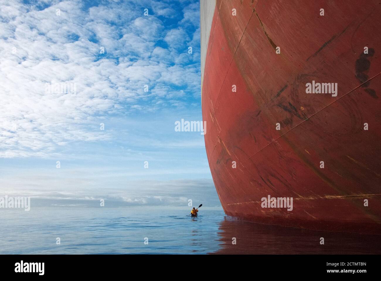 Sea kayaker dwarfed by the bulk carrier Magsenger 19 in Mounts Bay ...