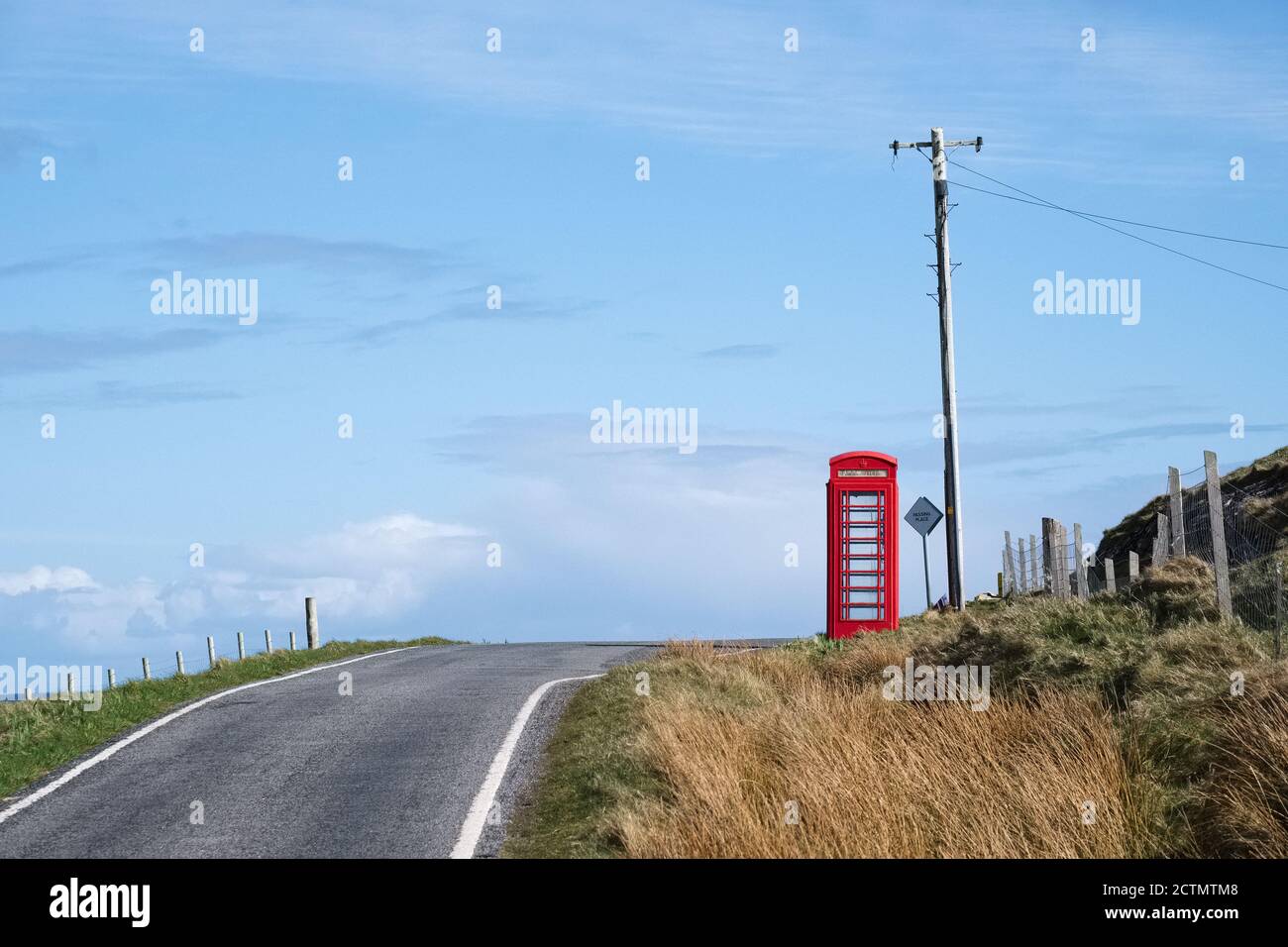 Traditional red telephone box by a country road on the Isle of Barra ...